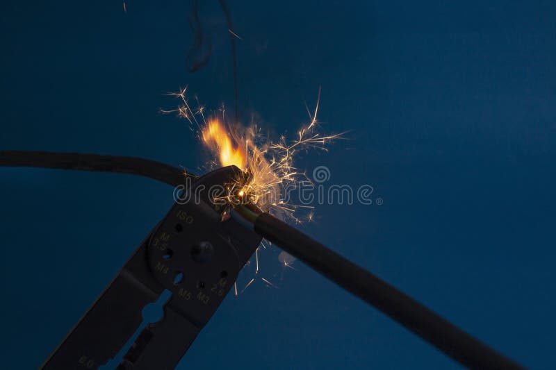 Flame and Sparks with Wire Stripper Cutting Electrical Cables, on Dark ...