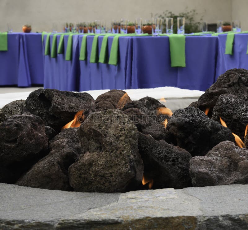 Flames from a Fire Pit in Front of a Blue and Green Table Setting with ...