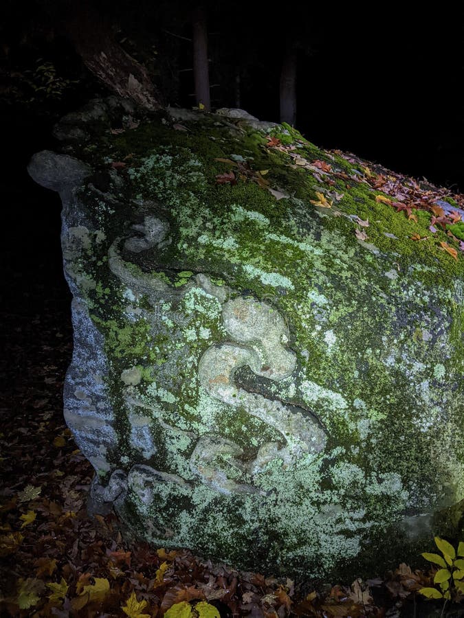A Flash Light Illuminates a Snake Carved into a Boulder Stock Photo ...