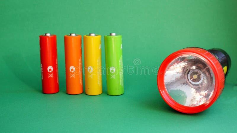 Flashlight and Four AA Batteries on a Green Background. Illumination ...