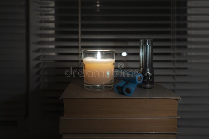 A Flashlight and Rechargeable Batteries Lie in a Dark Empty Room by the ...