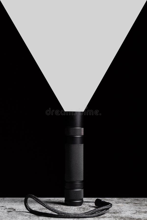 Flashlight Stands on a Table with a Wide Beam of Light Upwards and Copy ...