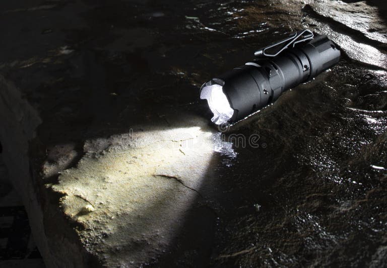 Flashlight on a wet rock stock image. Image of polymer - 253089839