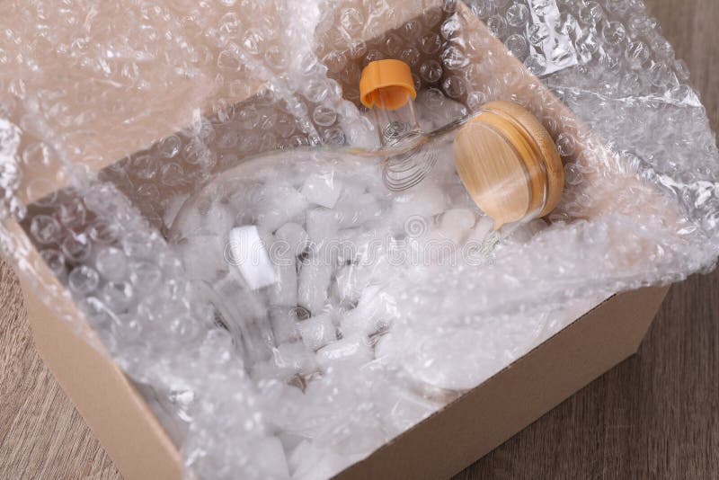 Flask with Bubble Wrap and Packaging Foam in Cardboard Box on Wooden ...