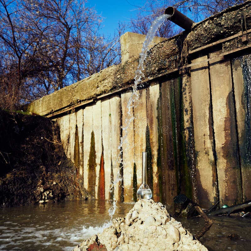 Flask with Clean Drinking Water Against the Background of Sewage ...