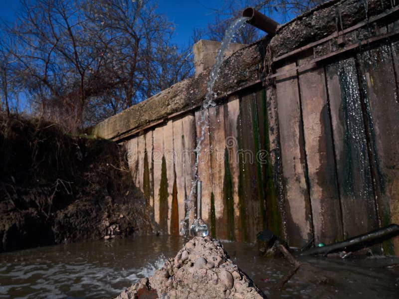 Flask with Clean Drinking Water Against the Background of Sewage ...