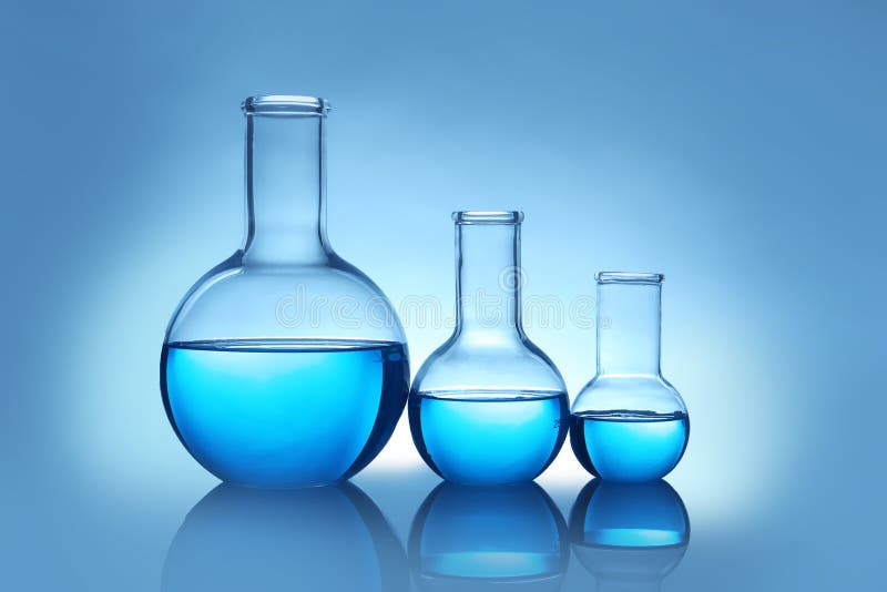 Flasks with Liquid on Table Against Color Background Stock Image ...