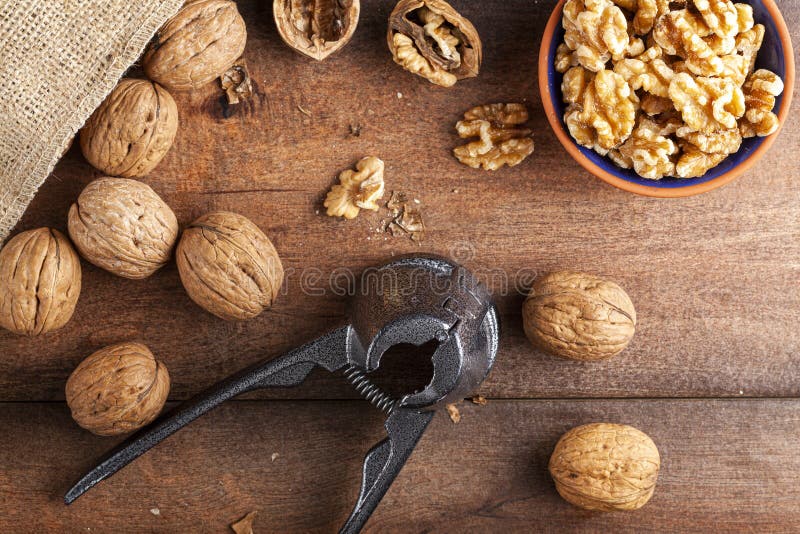 Walnuts in Shell with Nut Cracker on Wooden Background Stock Image ...