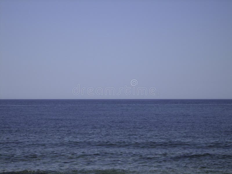 The Flat Line of the Sea Horizon between the Cloudless Sky and the Blue ...