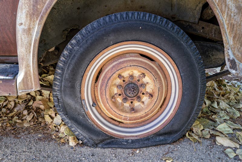 A Flat Tire on a Rusty Antique Car Stock Image - Image of rubber, flat ...