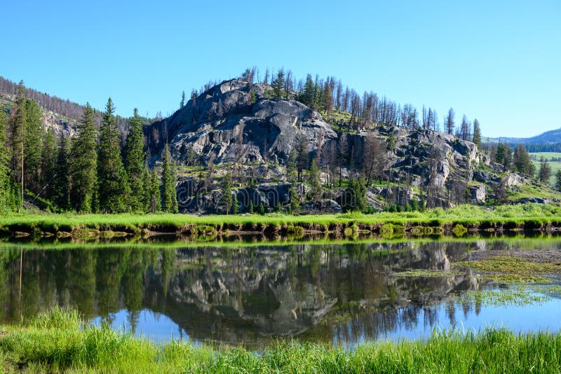 Flat Water Reflects Rocks in Yellowstone Wilderness Stock Photo - Image ...