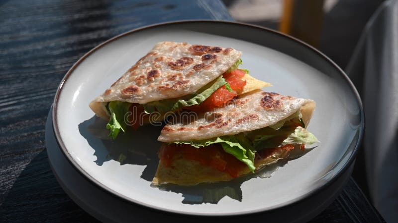 A Flatbread Stuffed with Fish and Cheese is Rotated on a Round Table ...