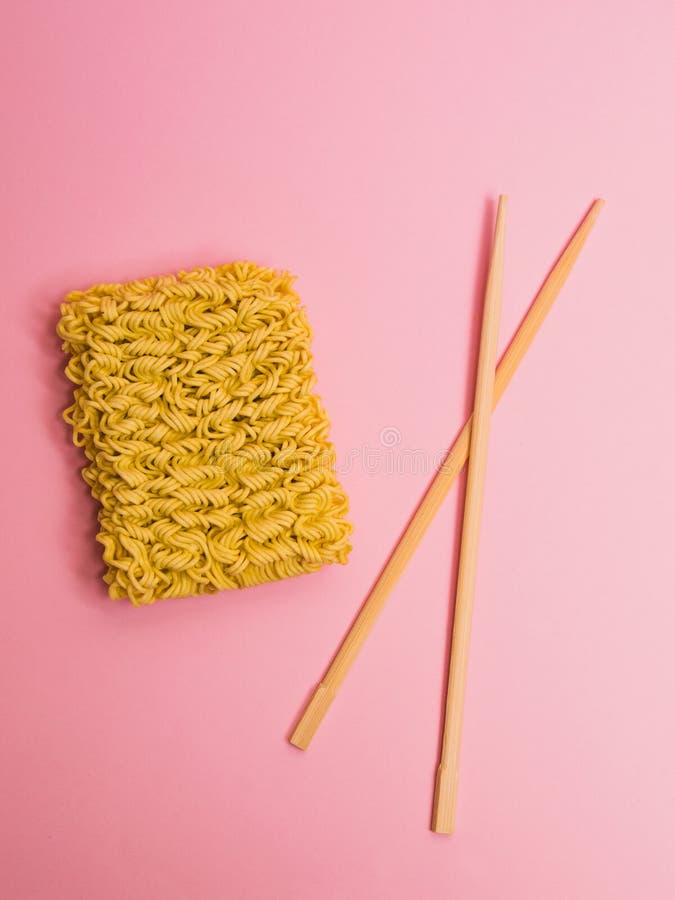 Chopsticks and Raw Instant Noodles on Pink Background, Side View Stock ...