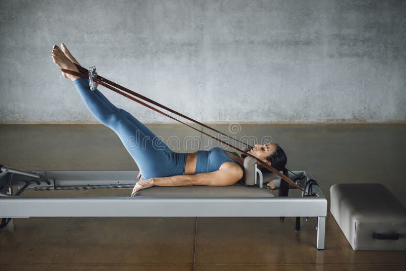Flexible Female Using Pilates Reformer Machine in Gym Stock Image ...