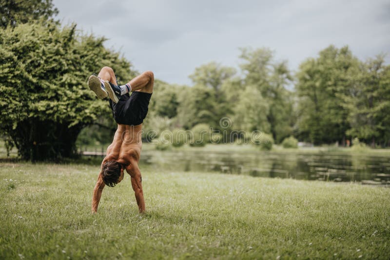 Flexible Man Doing Back Flip in Outdoor Park Setting Surrounded by ...
