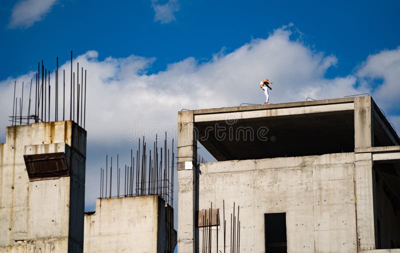 Flexible Woman Standing on the Edge of Building Under Construction ...