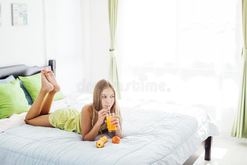 Flicka Som Dricker Fruktsaft Och Kopplar Av I Sovrum Fotografering för ...