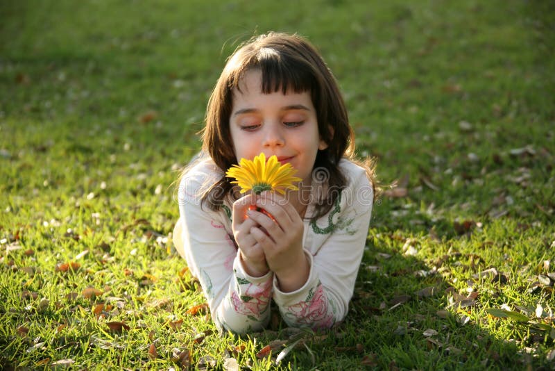 Flicka som ser en blomma fotografering för bildbyråer. Bild av utbilda ...