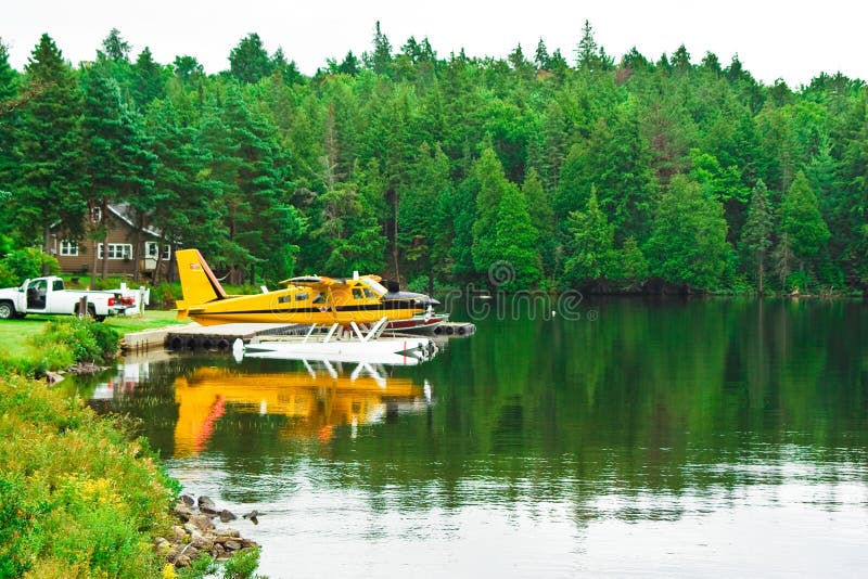 Alaska Float Plane Moored at Dock Amid Foliage Reflections Stock Image ...