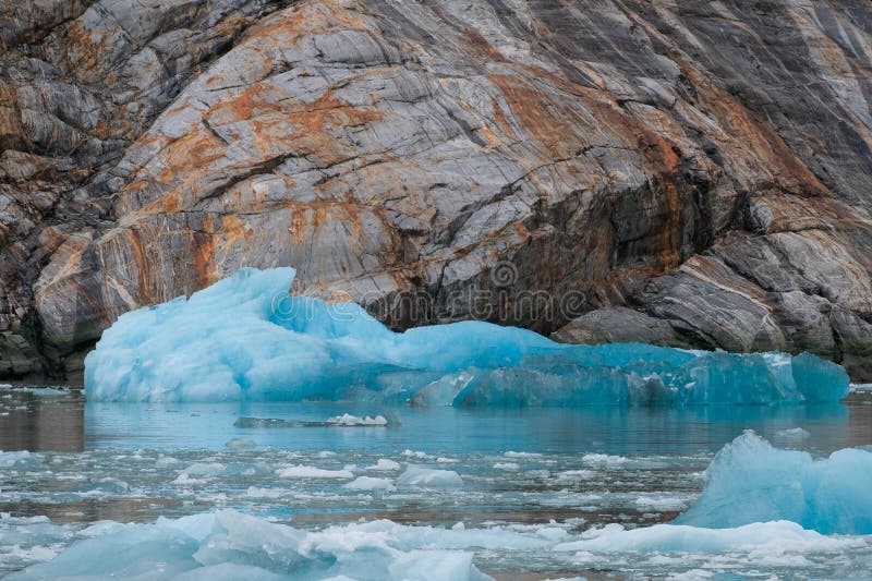 Floating Ice and Weathered, Eroded Rock Face in Alaska Stock Image ...