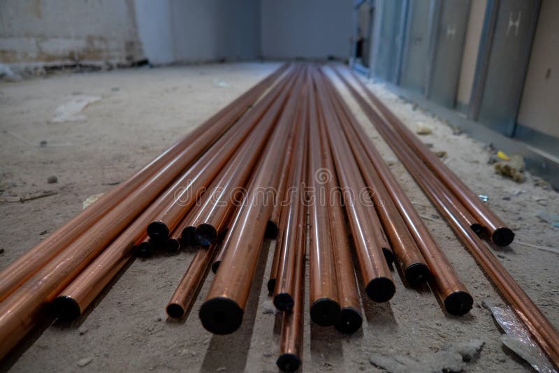 On a Floor of a Construction Site are Many Copper Pipes Stock Photo ...