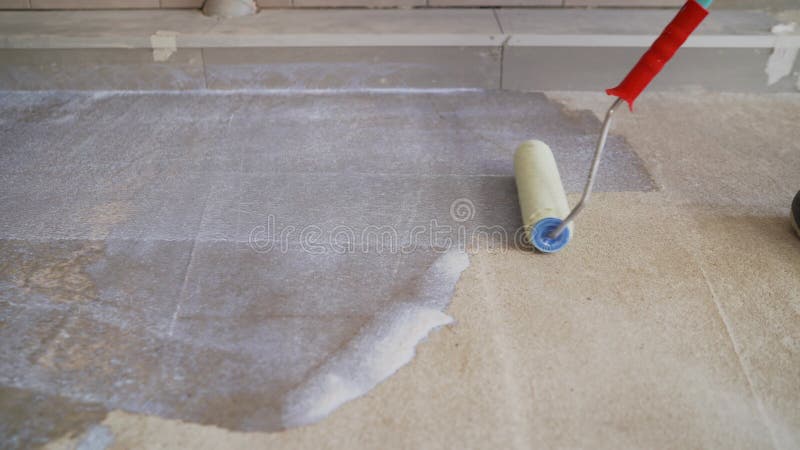 Floor Priming Process. a Worker Applies Primer To a Concrete Floor ...