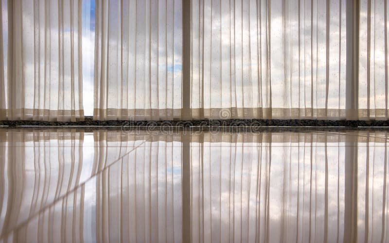 On the Floor is Reflect of Curtains with a Wall of Square Windows Stock ...