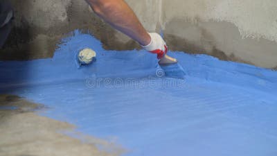 A Worker is Applying Waterproofing Paint To the Floor in the Bathroom ...