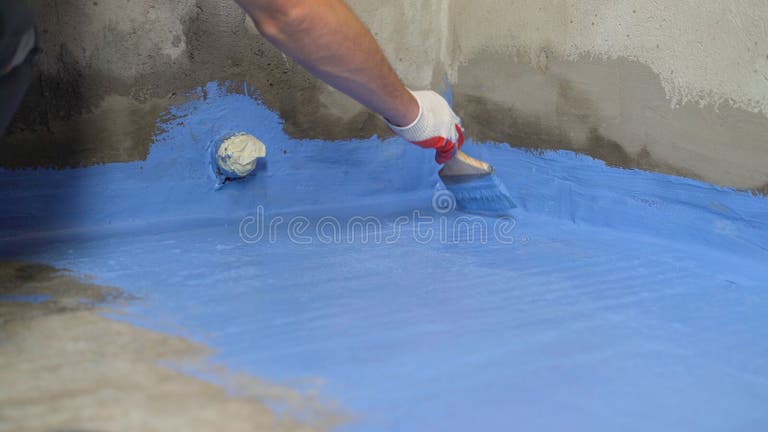 A Worker is Applying Waterproofing Paint To the Floor in the Bathroom ...