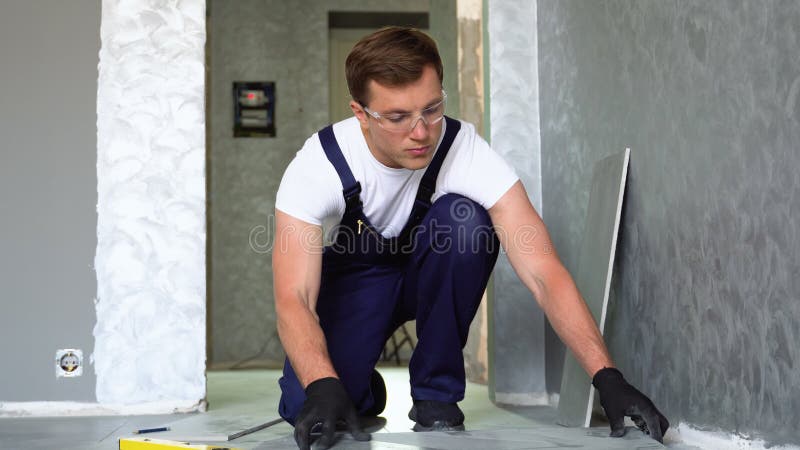 Flooring and Tiling. Professional Tiler Placing Floor Tiles on Adhesive ...