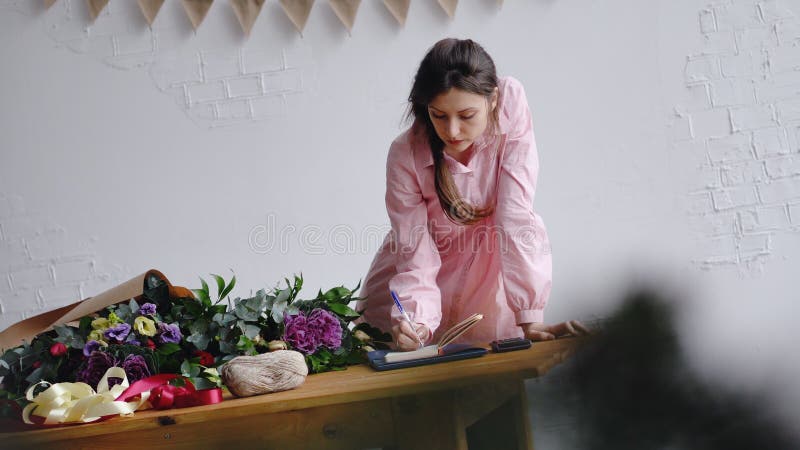 Florist Girl Writes Notes in a Notebook Behind the Counter Stock Photo ...