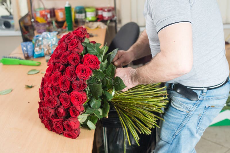 Florist at Work Making a Bouquet of Red Roses. Focus on the Bouq Stock ...