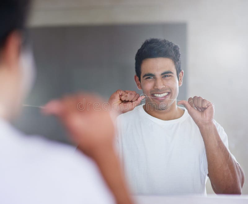 Flossing for a Complete Clean. a Happy Young Man Flossing His Teeth at ...