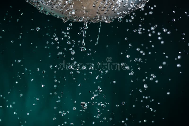 Flow and Drops of Water through Holes in a Colander on a Dark ...
