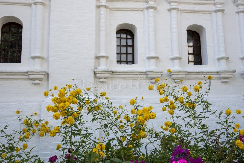 A Flowerbed with Bright Flowers Against a White Monastery Wall Stock ...