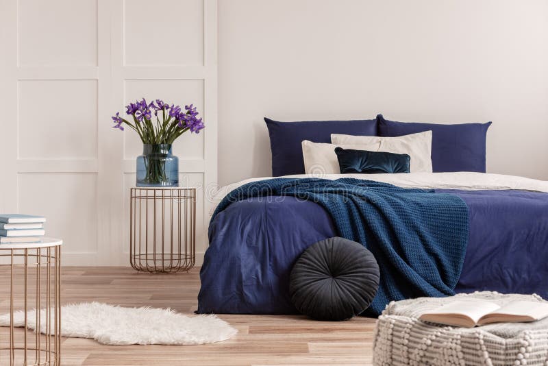 Flowers in Vase on Bedside Table Next To King Size Bed with Navy Blue ...