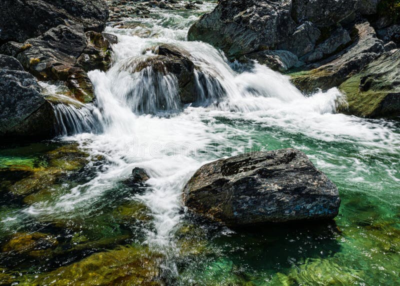 Flowing River Surrounded by Rocks Under the Sunlight at Daytime ...