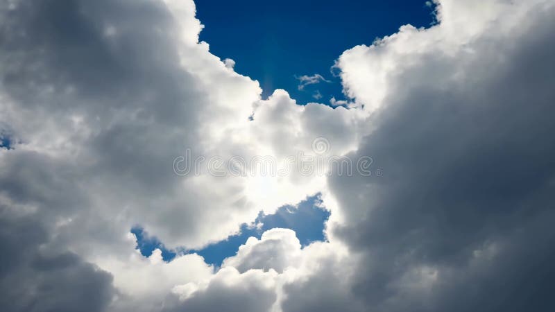Fluffy White Clouds Float in Blue Sky, Sun Shines through Clouds Stock ...