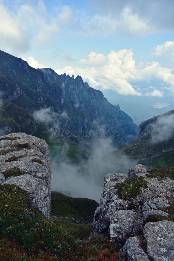 Fluffy White Clouds among the Mountain Ridges. Mist at High Altitude ...