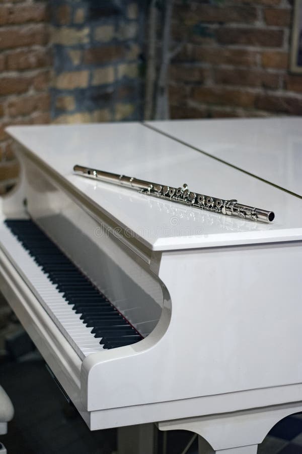 Flute on a white piano stock image. Image of sound, instrument - 365512021