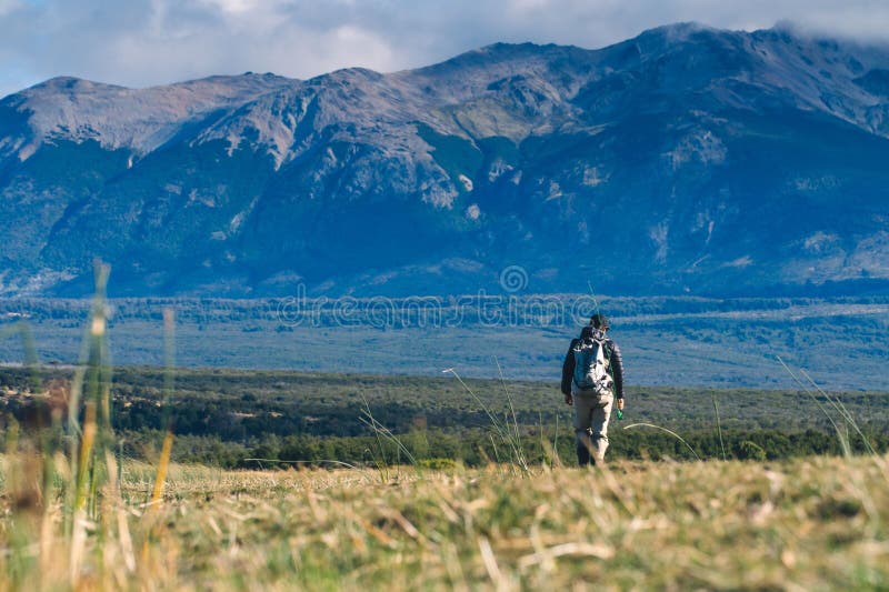 Fly Fisherman Walking in the Grassy Field on the Background of ...