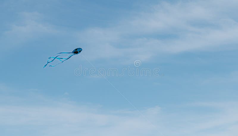 Flying Blue Kite with a Face on it in a Blue Clear Sky Stock Image ...