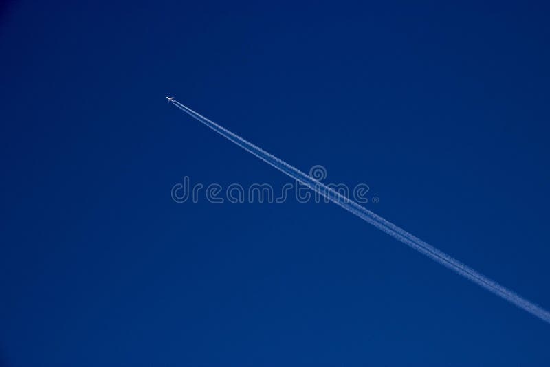 Flying Plane with an Inversion Track on a Blue Sky Background Stock ...