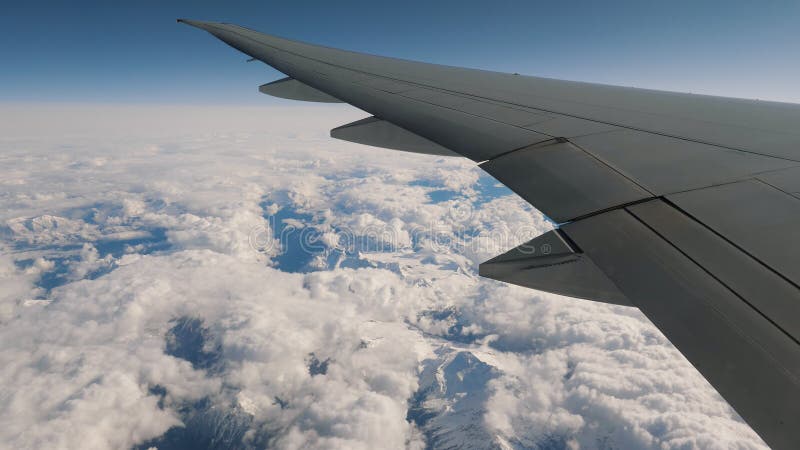View from Height of Flying Plane on Wing and Snow Capped Mountains ...