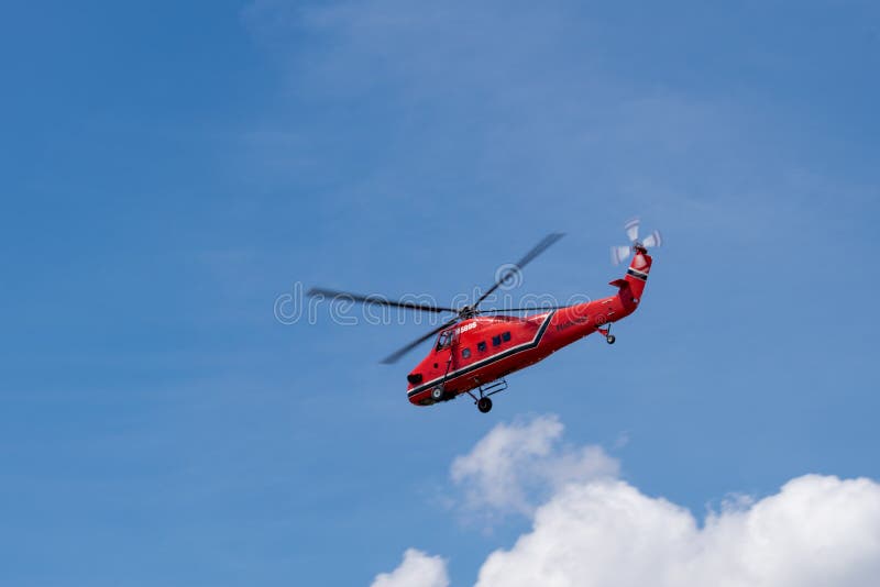 Red Helicopter Against the Blue Sky Performing at Airshow Editorial ...