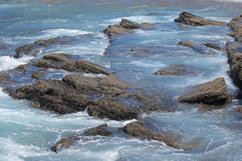 SEAWATER WASHING OVER ROCKS on BEACH Stock Image - Image of shore ...