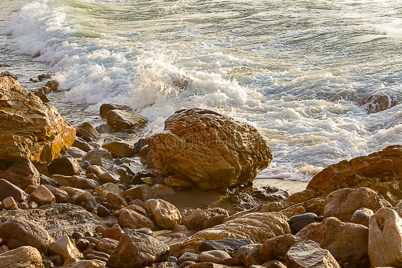 Foaming Wave Breaking at Sunrise with Rocky Shoreline Stock Image ...