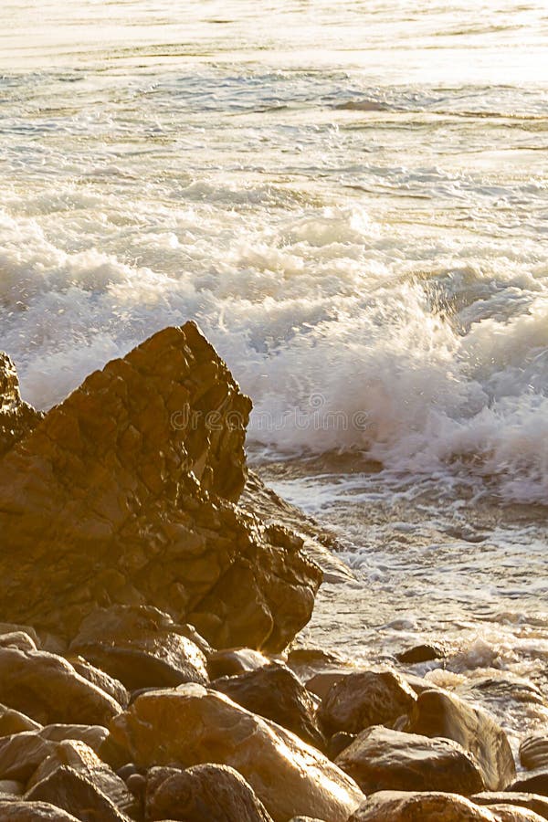 Foaming Wave Breaking at Sunrise with Rocky Shoreline Stock Image ...