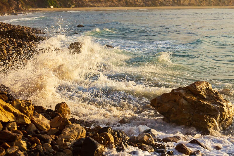 Foaming Wave Breaking at Sunrise with Rocky Shoreline Stock Photo ...