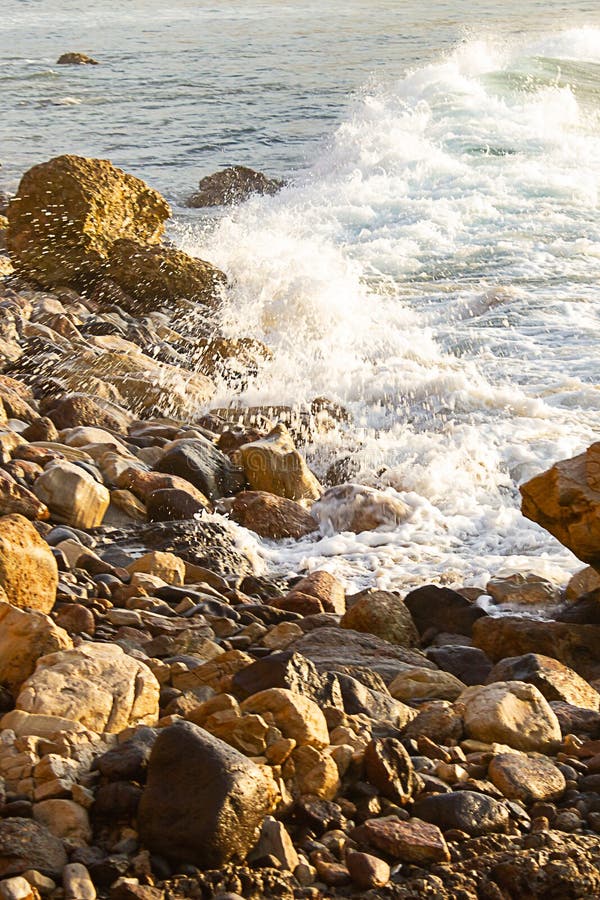 Foaming Wave Breaking at Sunrise with Rocky Shoreline Stock Image ...